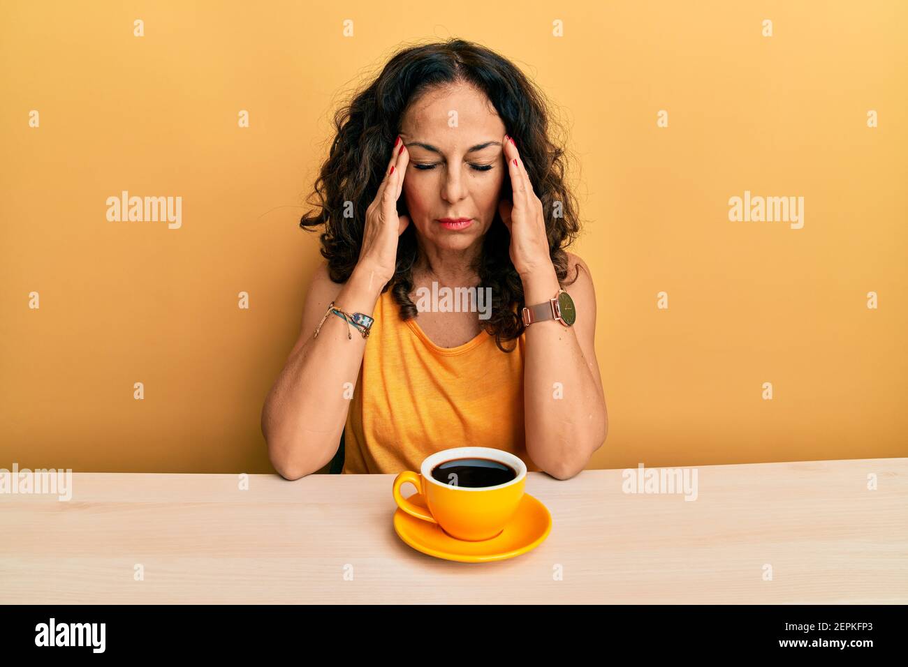 Beautiful middle age woman drinking a cup of coffee suffering from ...