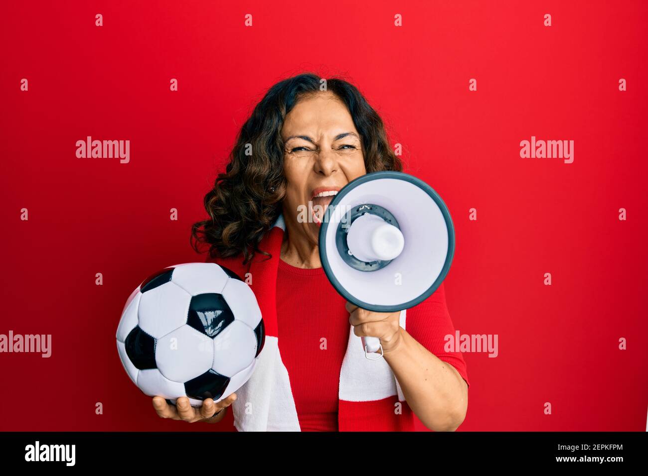 Middle age hispanic woman hooligan screaming through megaphone ...