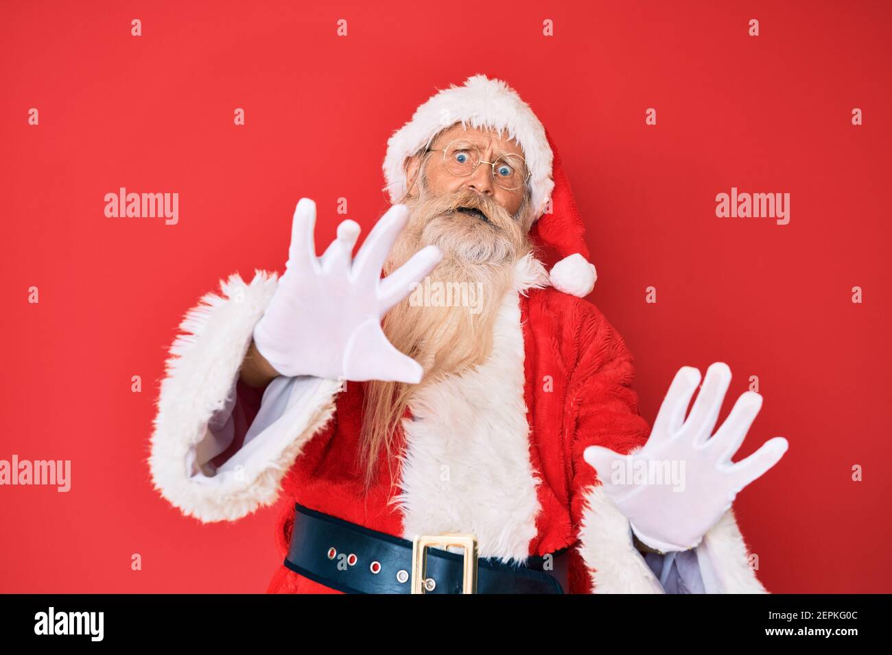 Old senior man with grey hair and long beard wearing traditional santa ...