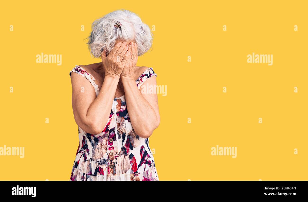 Senior grey-haired woman wearing casual clothes with sad expression ...