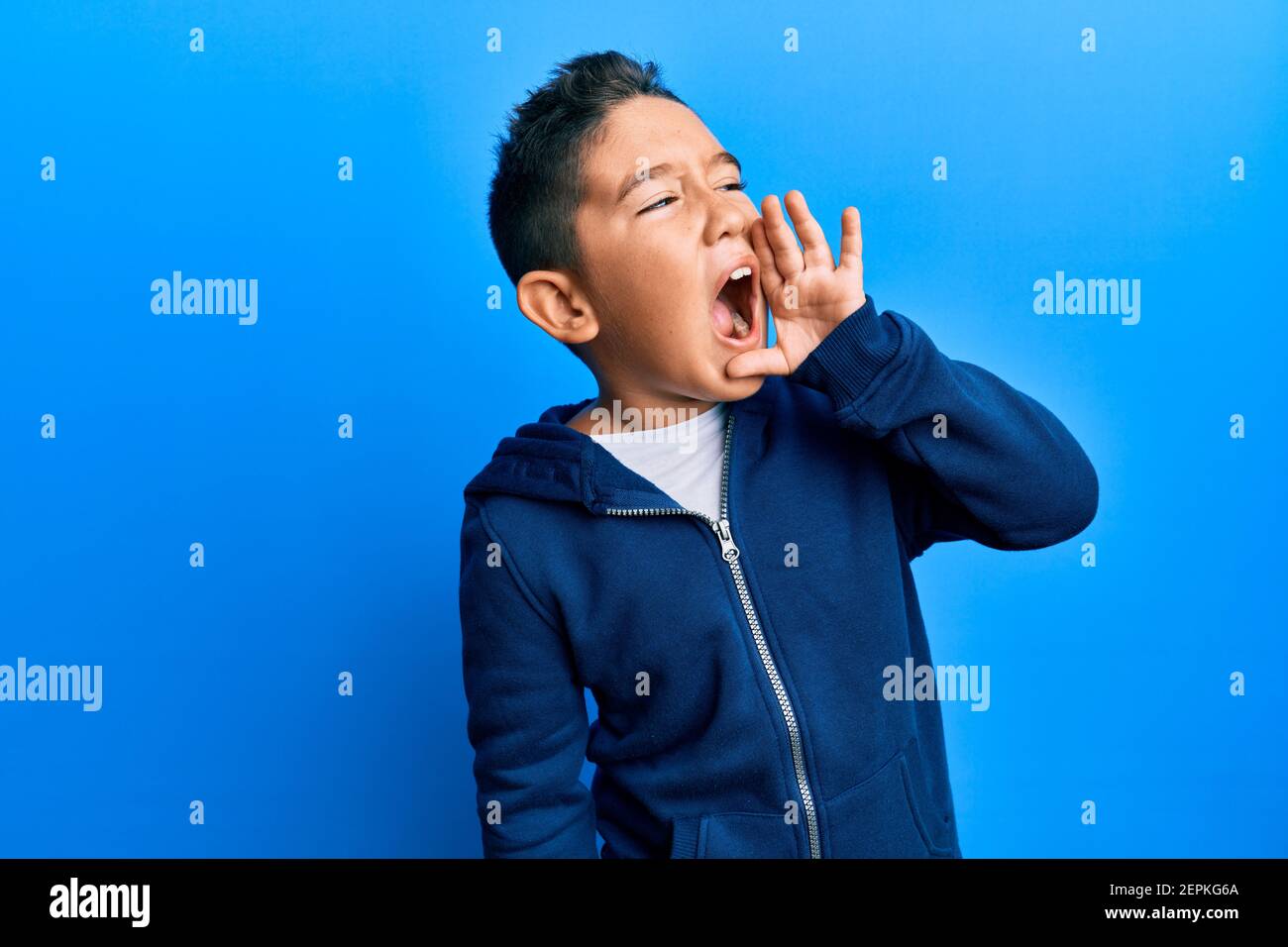 Little boy hispanic kid wearing casual sporty jacket shouting and ...
