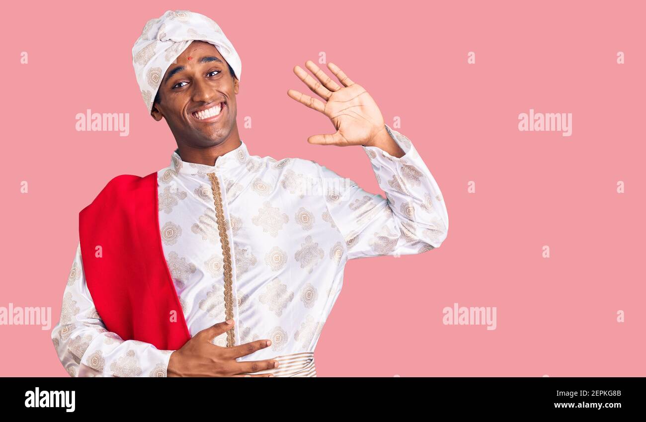 African handsome man wearing tradition sherwani saree clothes waiving ...