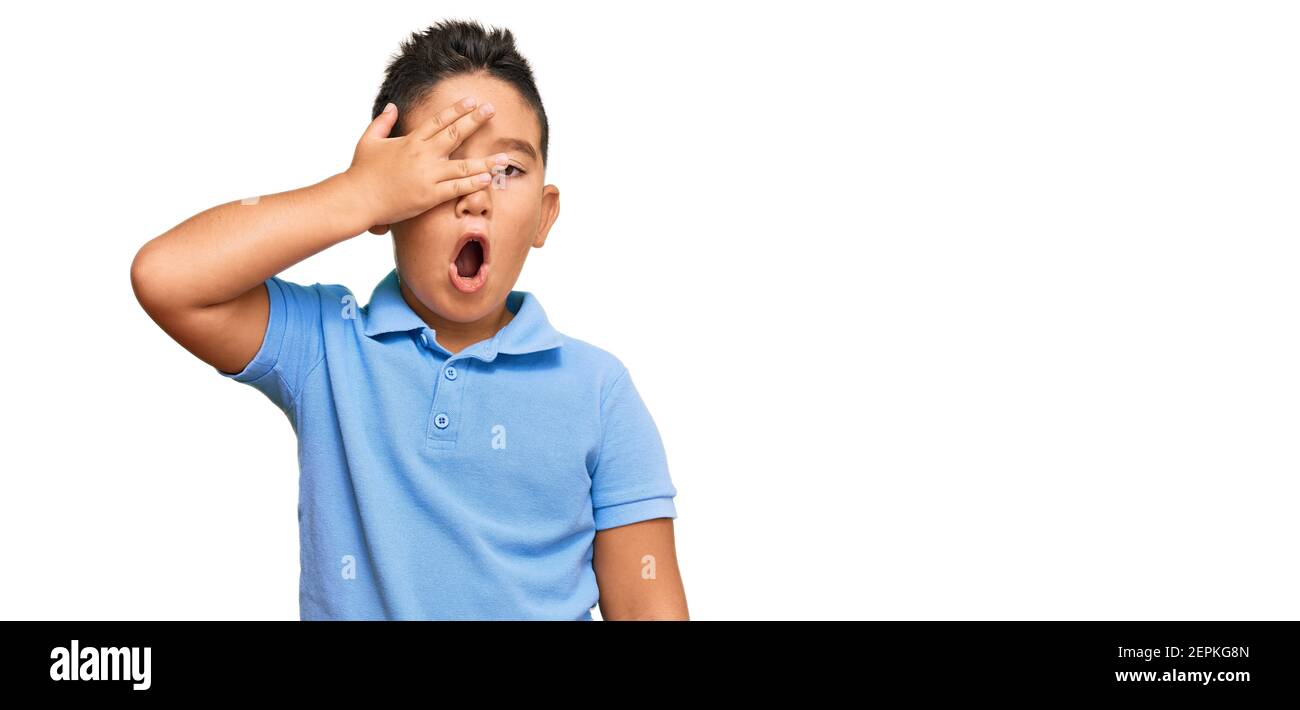 Little boy hispanic kid wearing casual clothes peeking in shock ...