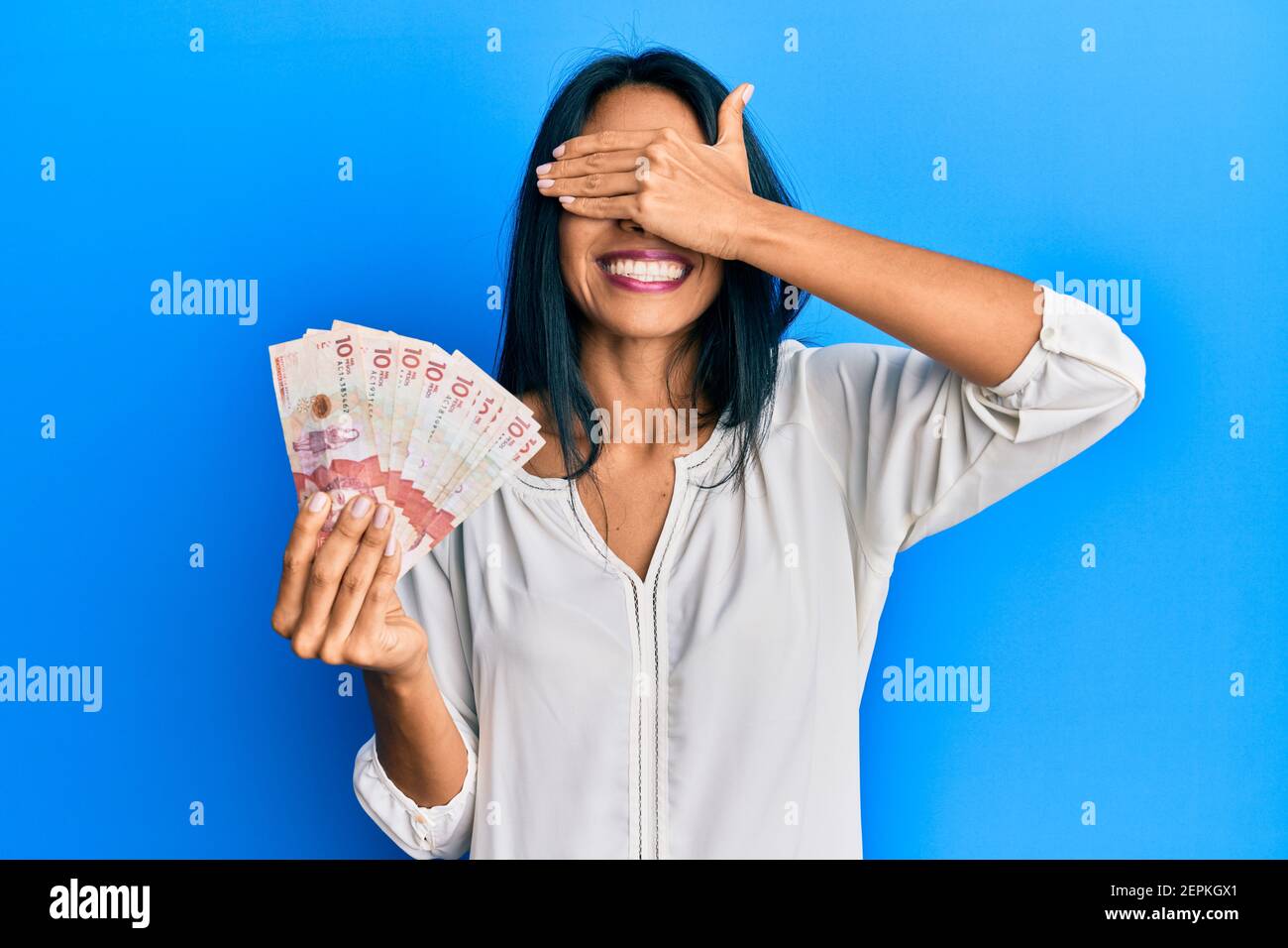 Young african american woman holding 10 colombian pesos banknotes ...