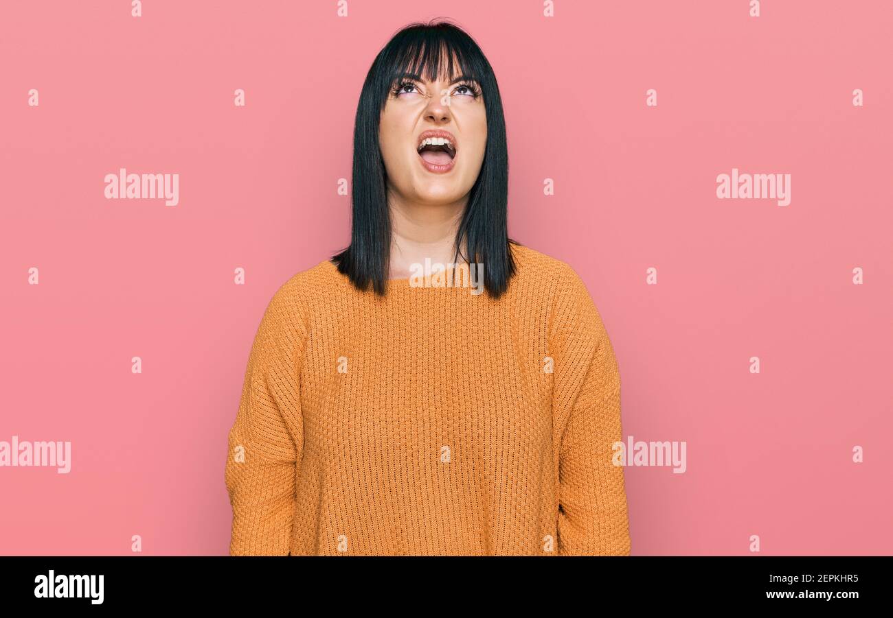 Young hispanic woman wearing casual clothes angry and mad screaming ...