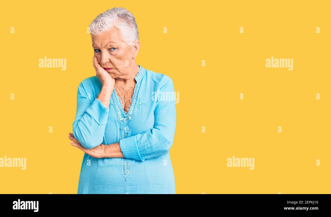 Senior beautiful woman with blue eyes and grey hair wearing summer ...