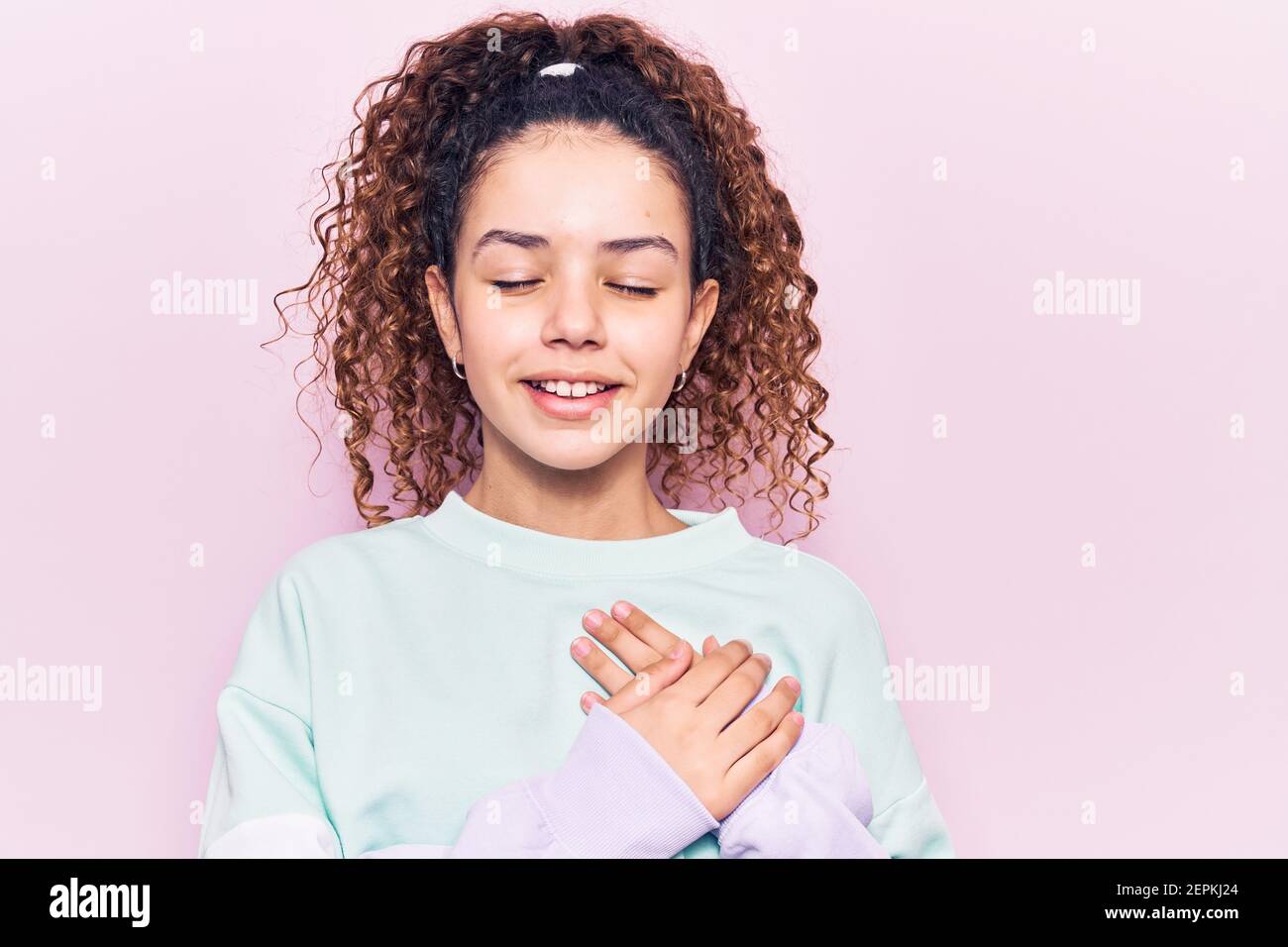 Beautiful kid girl with curly hair wearing casual clothes smiling with ...