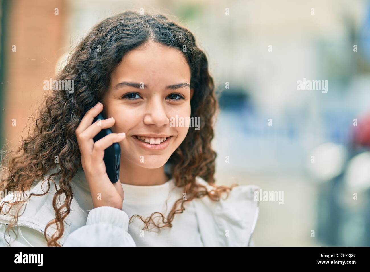 Beautiful hispanic girl smiling happy talking on the smartphone at the ...