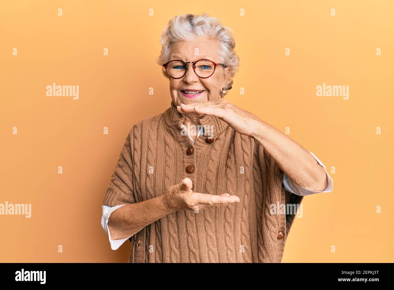 Senior grey-haired woman wearing casual clothes and glasses gesturing ...
