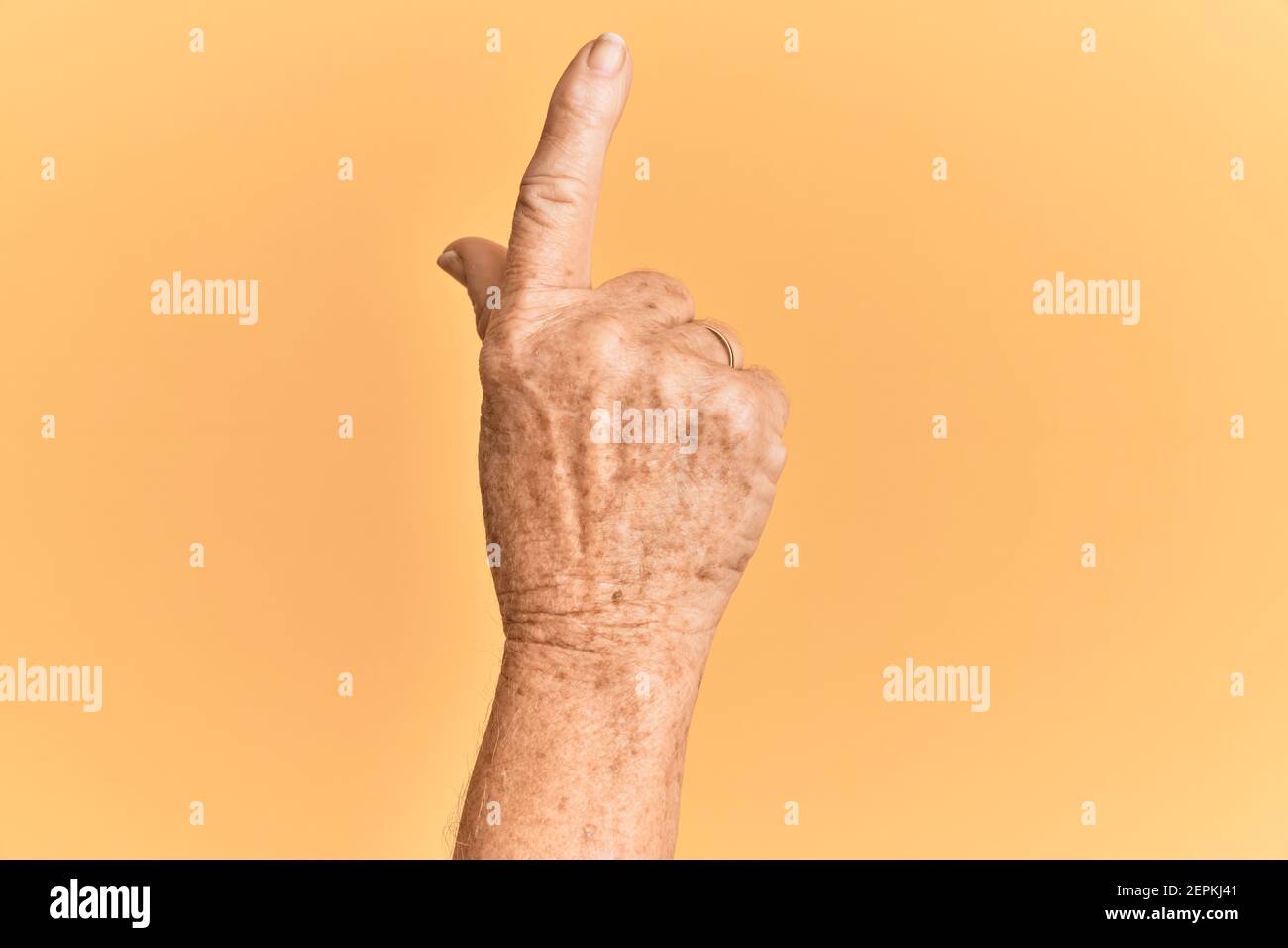 Senior caucasian hand over yellow isolated background counting number ...