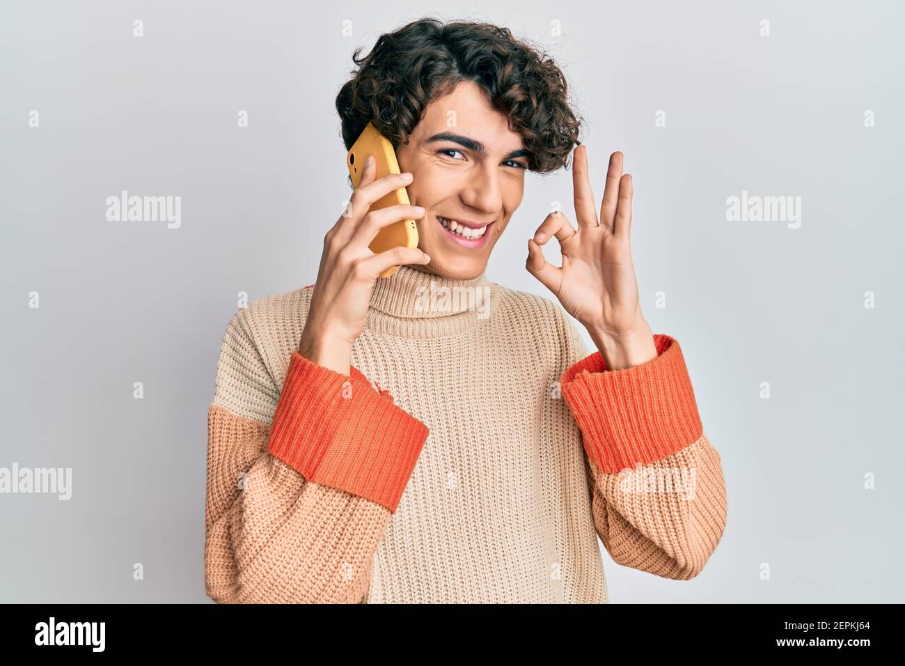 Hispanic young man having conversation talking on the smartphone doing ...