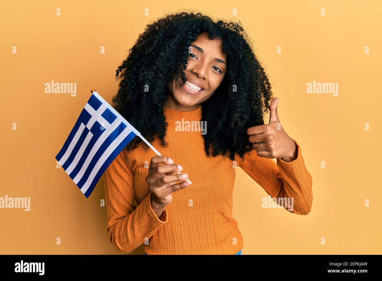 African american woman with afro hair holding greece flag smiling happy ...