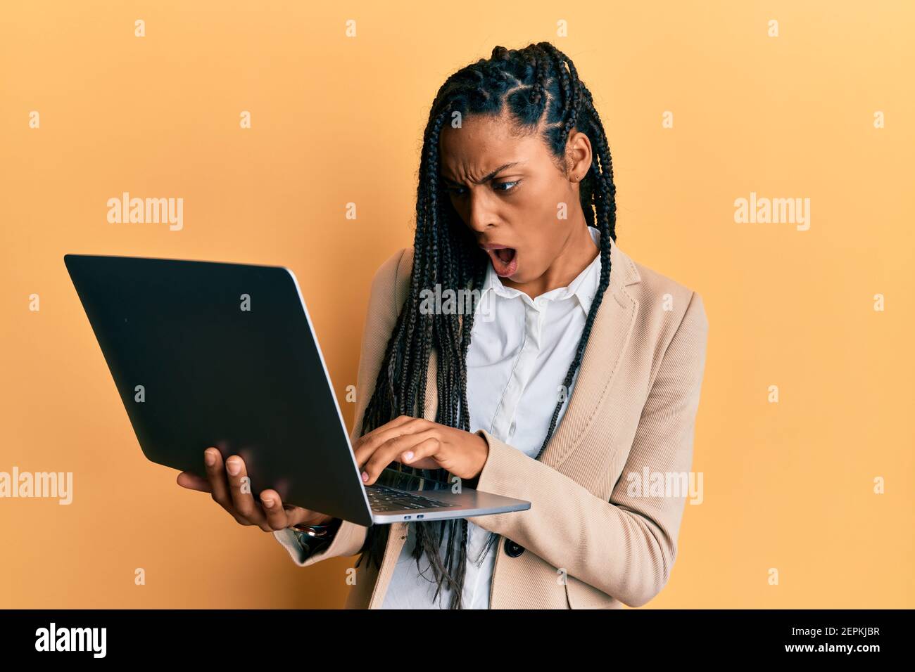 African american woman working using computer laptop in shock face ...