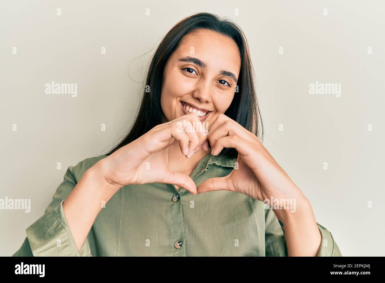 Young hispanic woman wearing casual clothes smiling in love showing ...