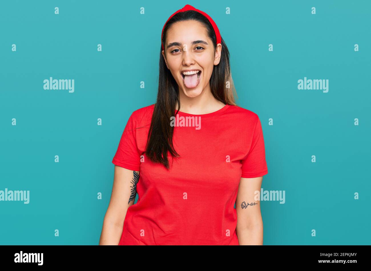 Young hispanic woman wearing casual clothes sticking tongue out happy ...
