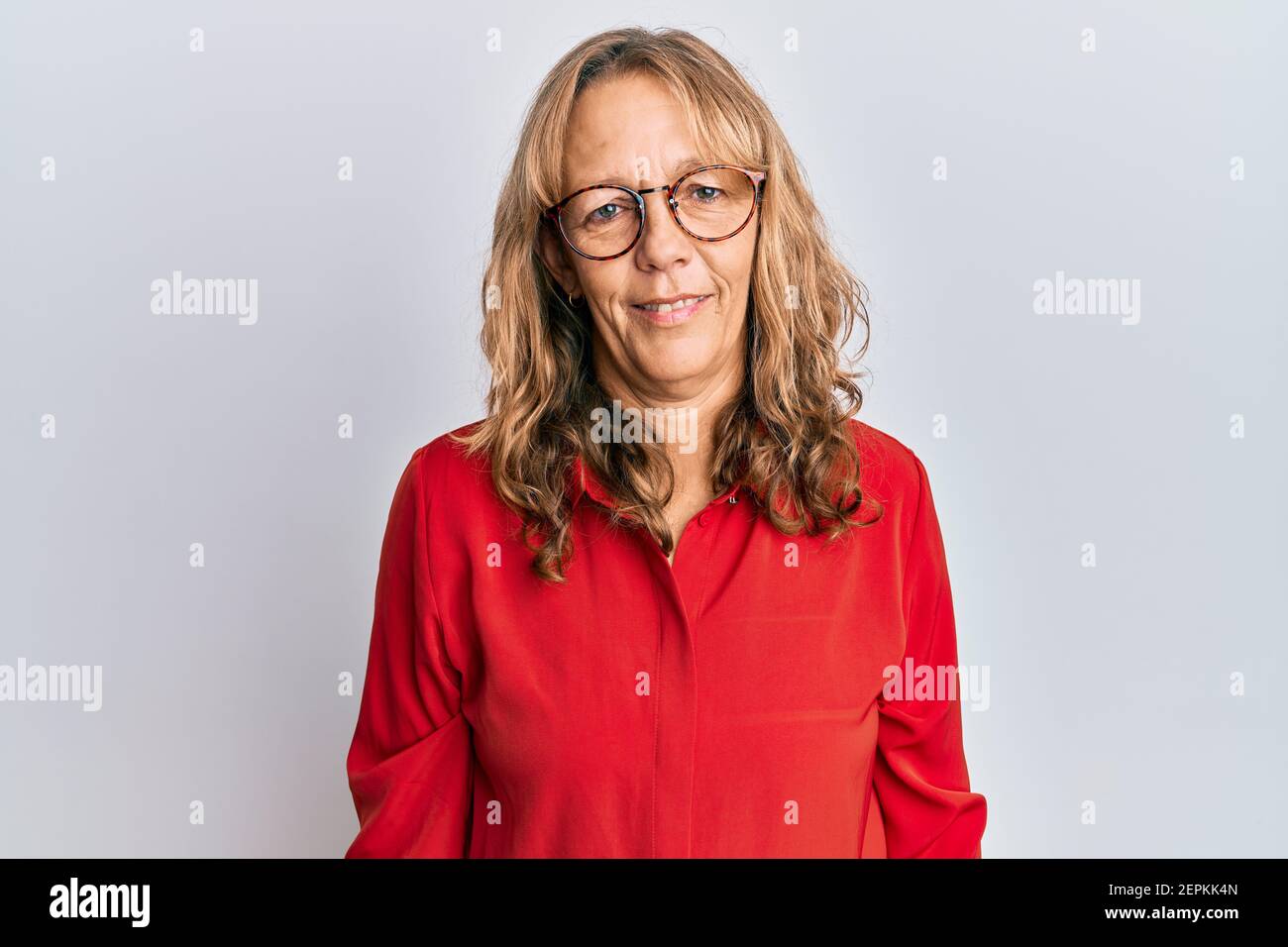 Middle age blonde woman wearing casual clothes and glasses with a happy ...