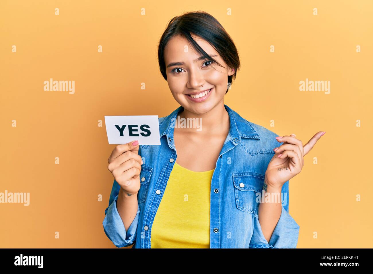 Beautiful young woman with short hair holding yes reminder smiling ...