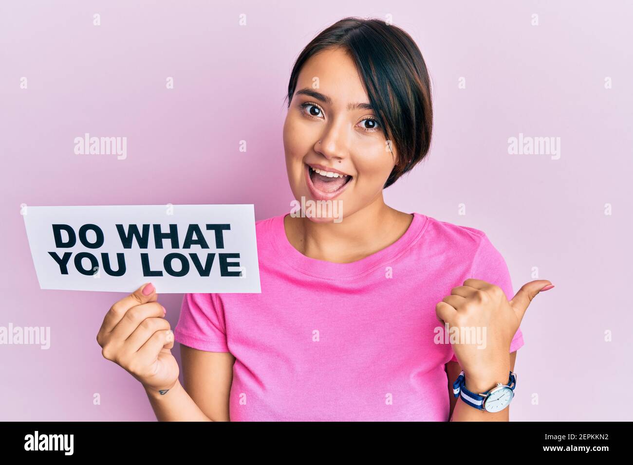 Beautiful young woman with short hair holding paper with do what you ...