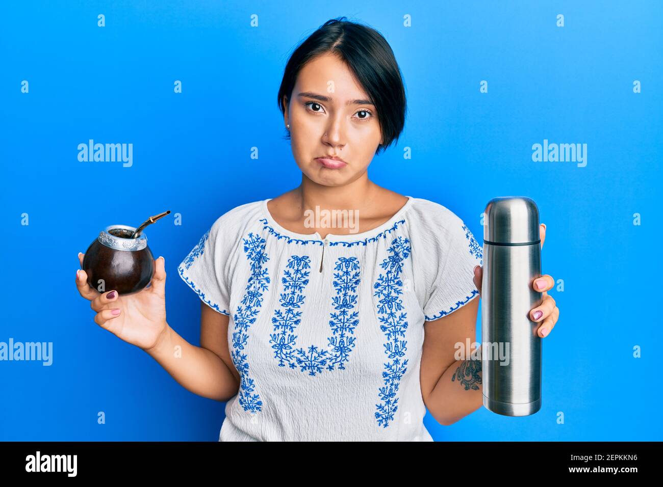 Beautiful young woman with short hair drinking mate infusion depressed ...