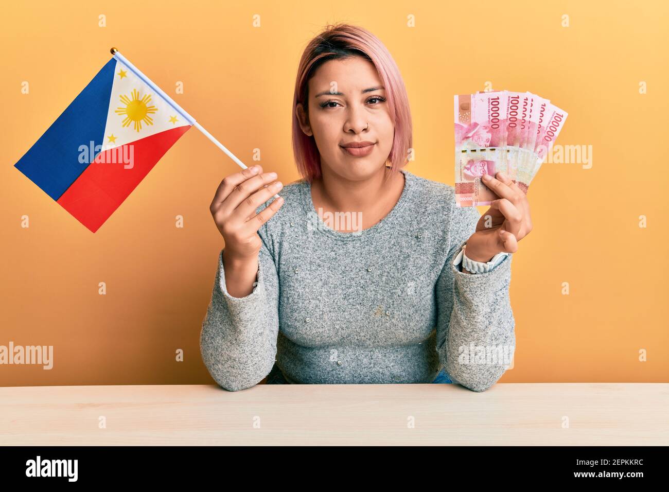 Hispanic woman with pink hair holding philippine flag and philippines ...