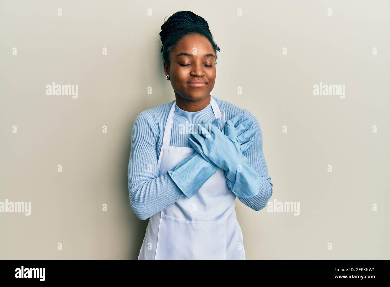 African american woman with braided hair wearing cleaner apron and ...