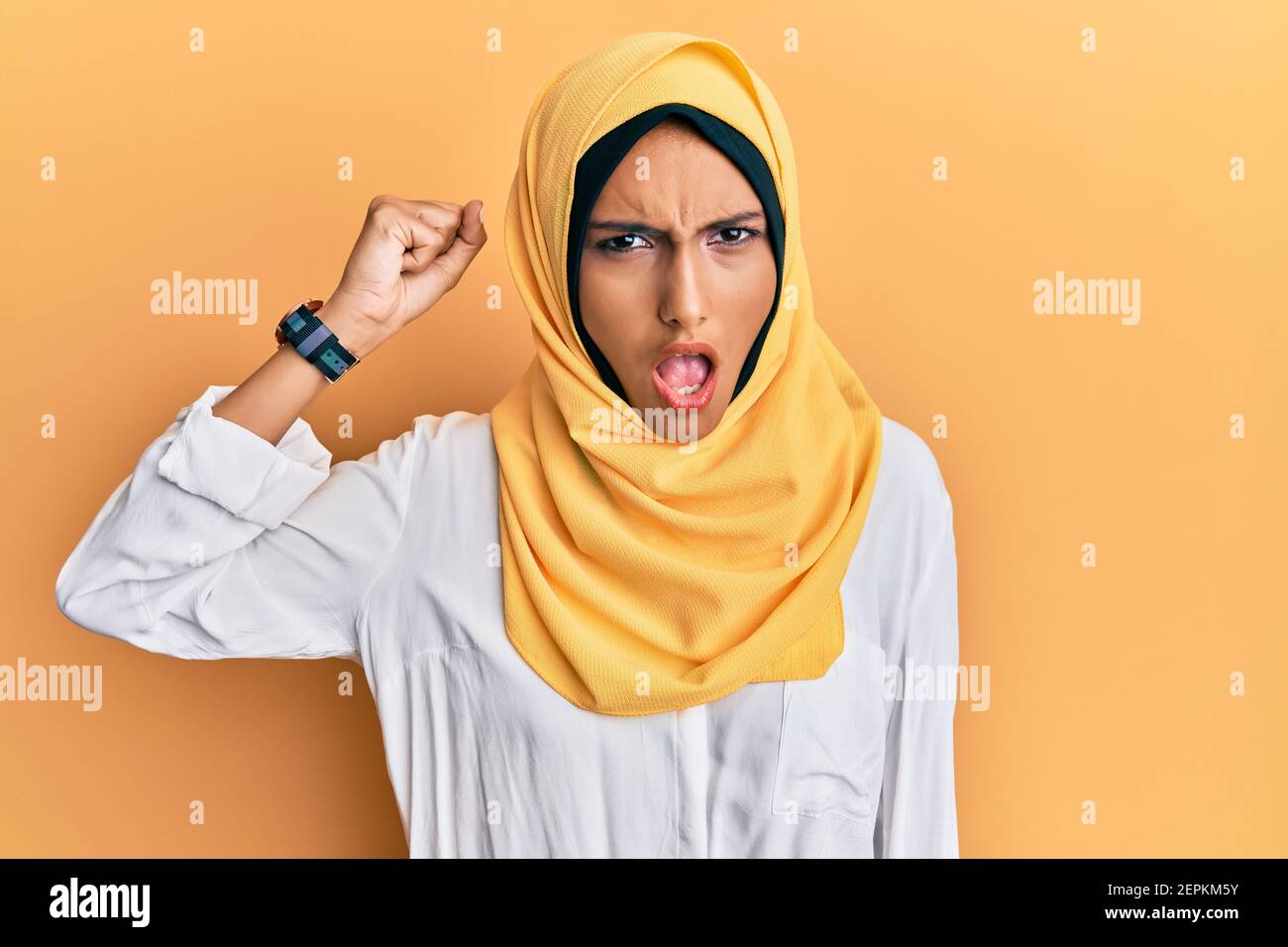 Young brunette arab woman wearing traditional islamic hijab scarf angry ...