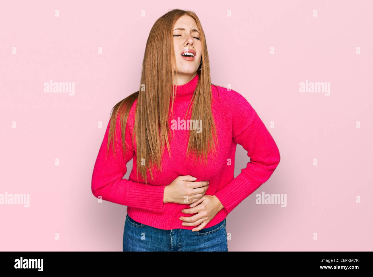 Young irish woman wearing casual clothes with hand on stomach because ...