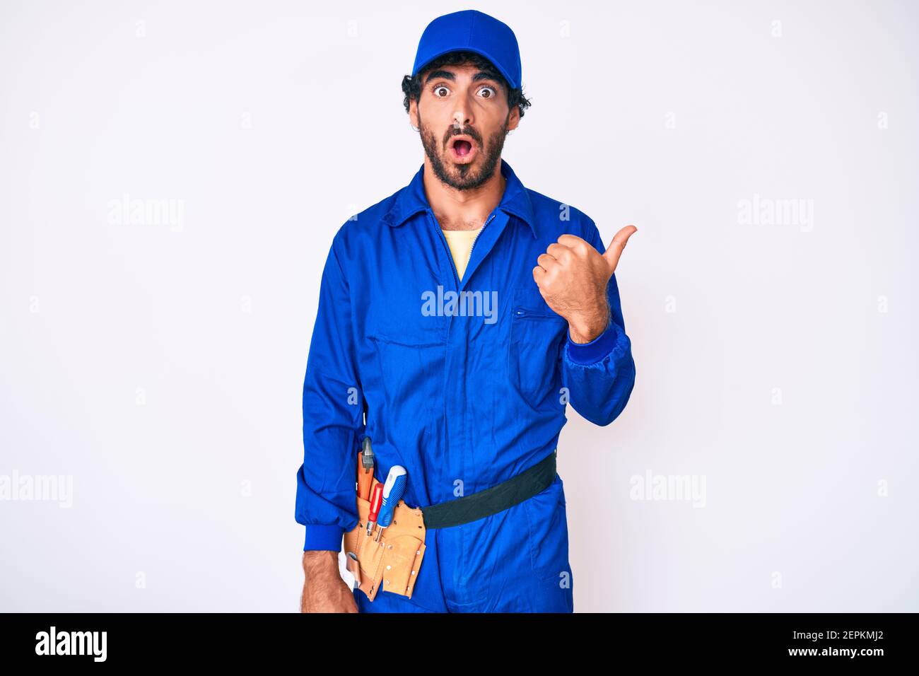 Handsome young man with curly hair and bear weaing handyman uniform ...