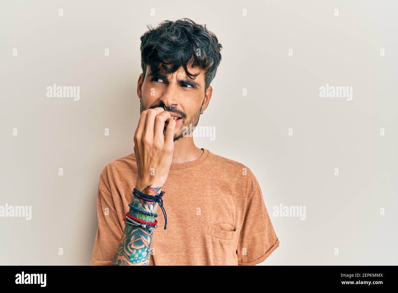 Young hispanic man wearing casual clothes looking stressed and nervous ...