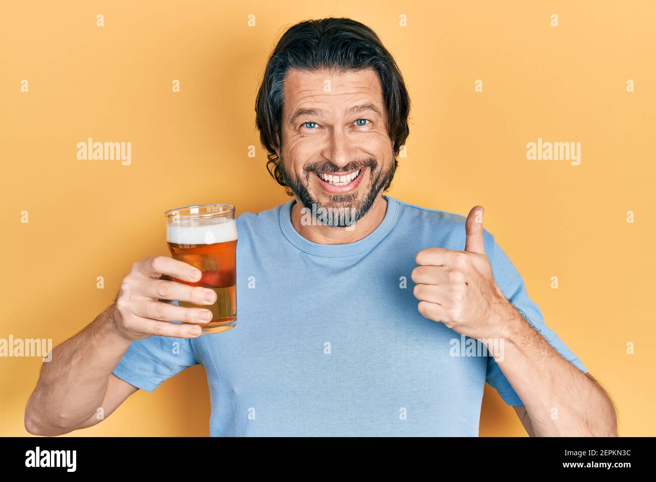Middle age caucasian man drinking a pint of beer smiling happy and ...