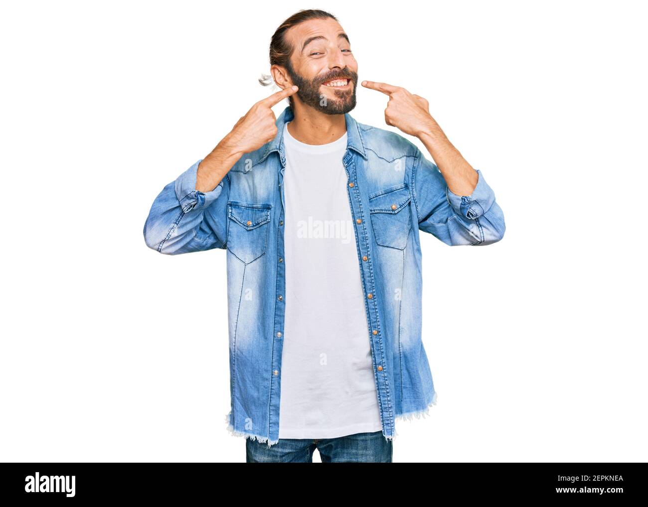 Attractive man with long hair and beard wearing casual denim jacket ...
