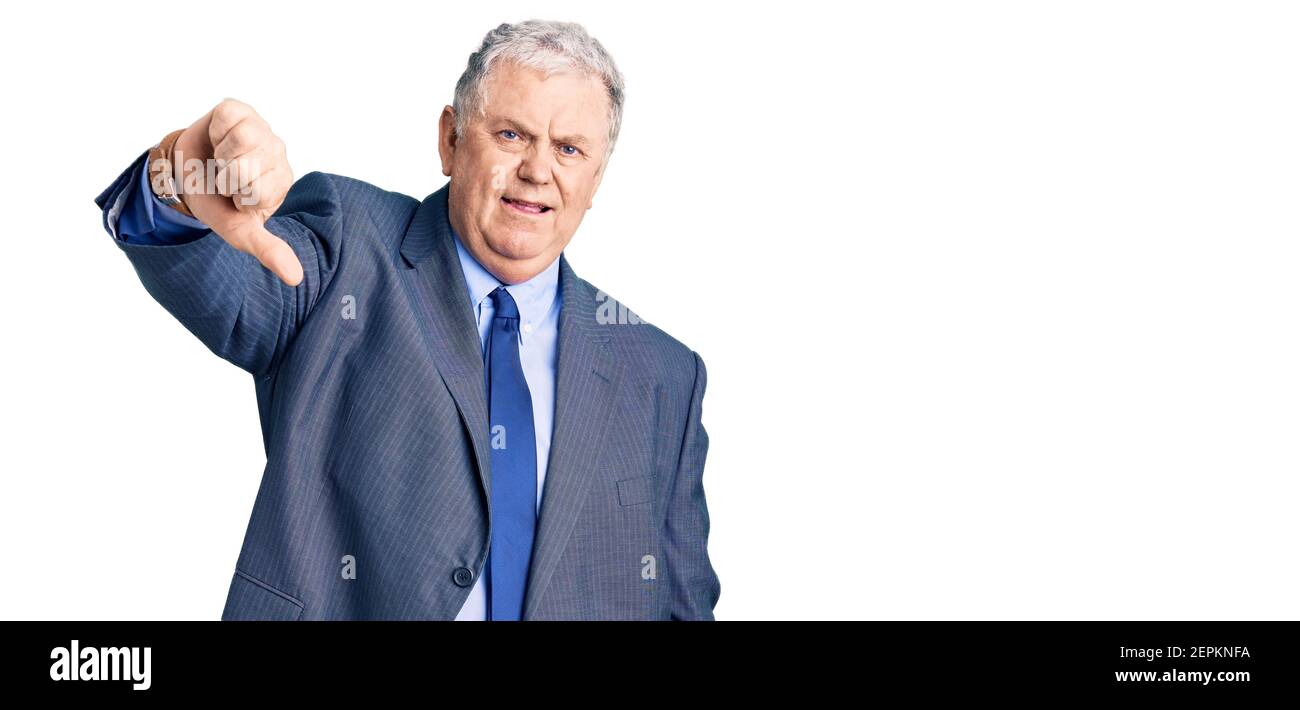 Senior grey-haired man wearing business jacket looking unhappy and ...