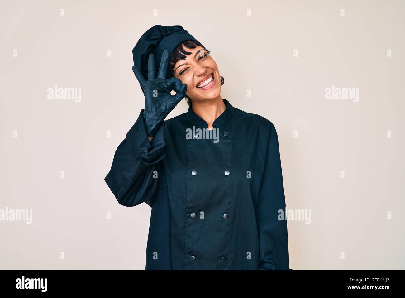 Beautiful brunettte woman wearing professional cook uniform smiling ...