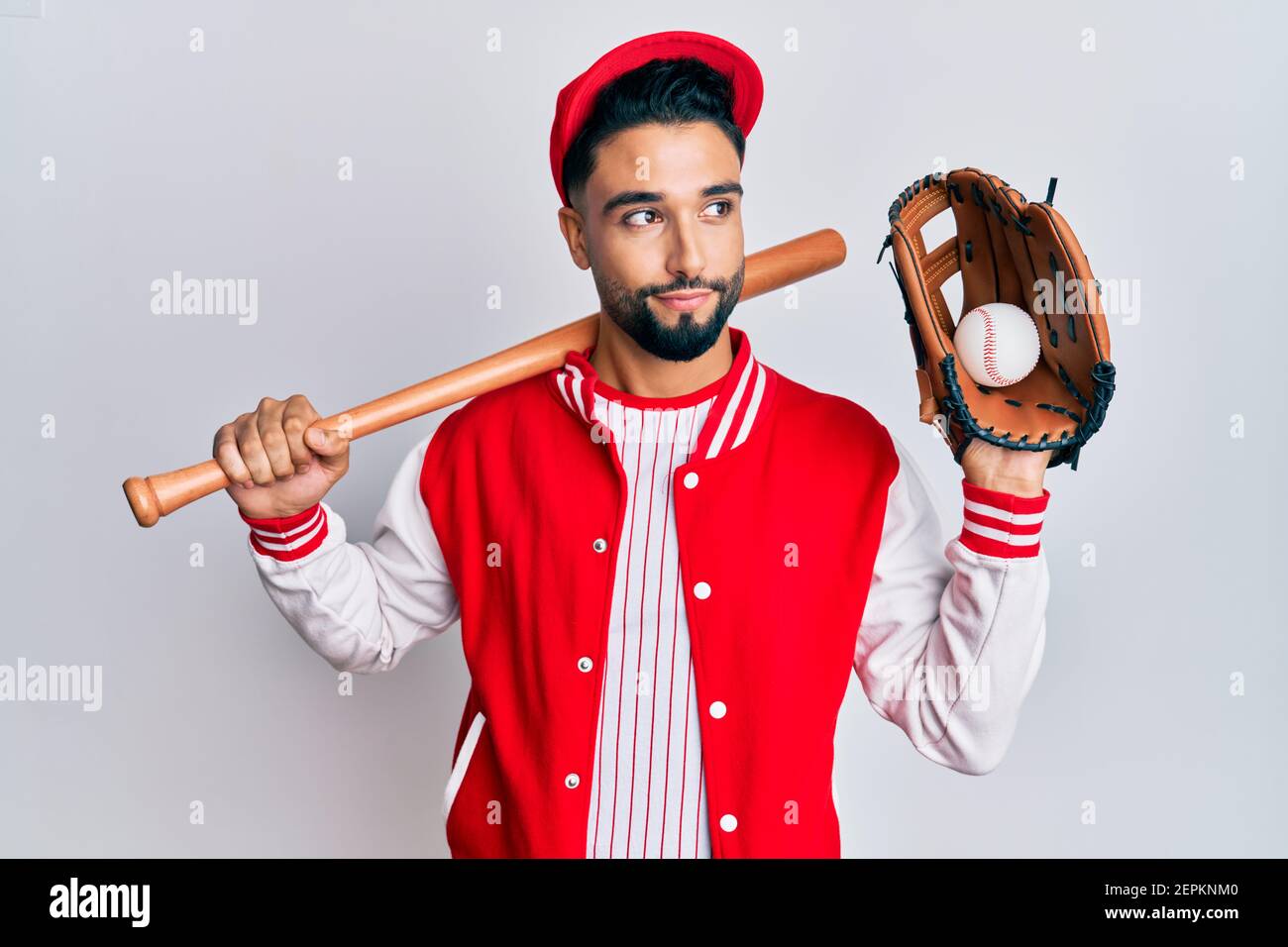 Young man with beard playing baseball holding bat and ball smiling ...