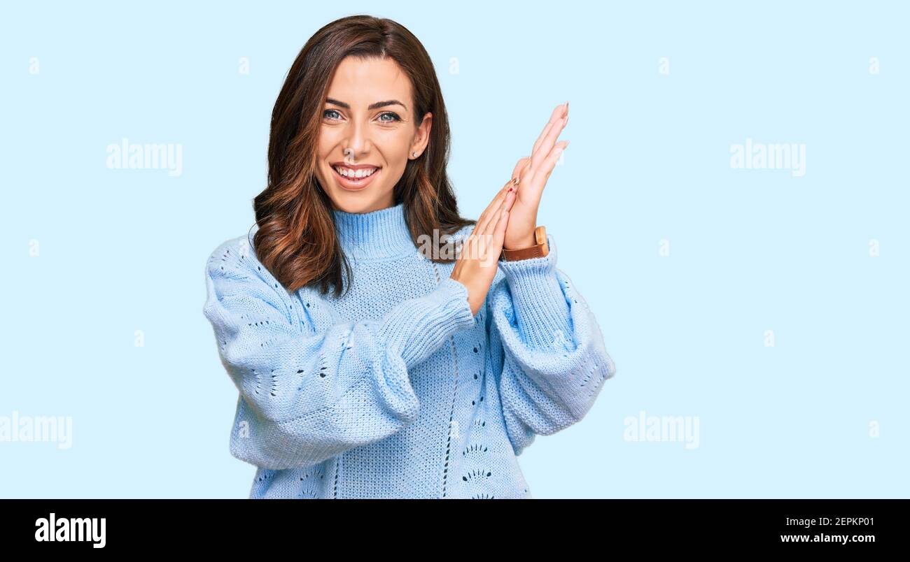 Young brunette woman wearing casual winter sweater clapping and ...