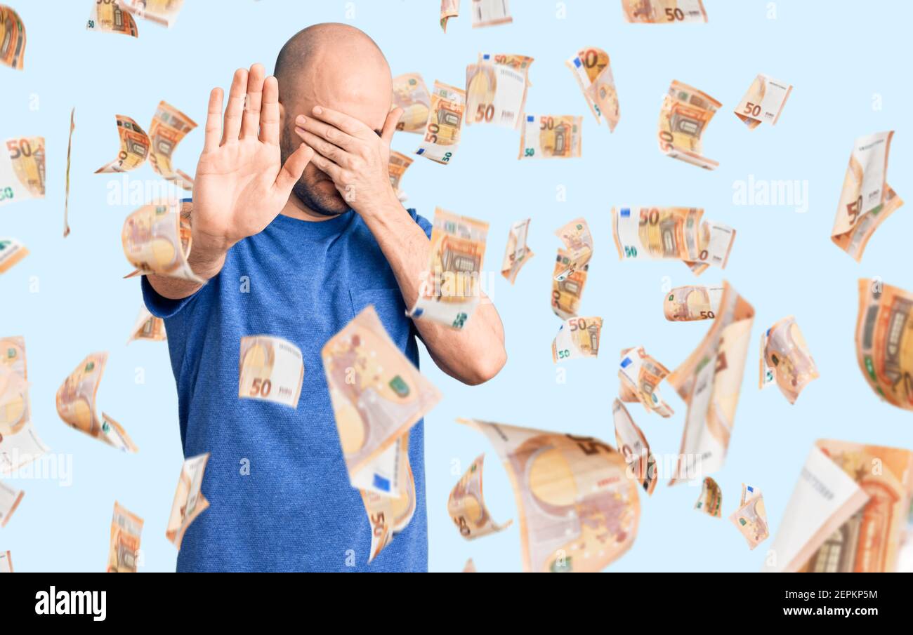 Young handsome man wearing casual t shirt covering eyes with hands and ...