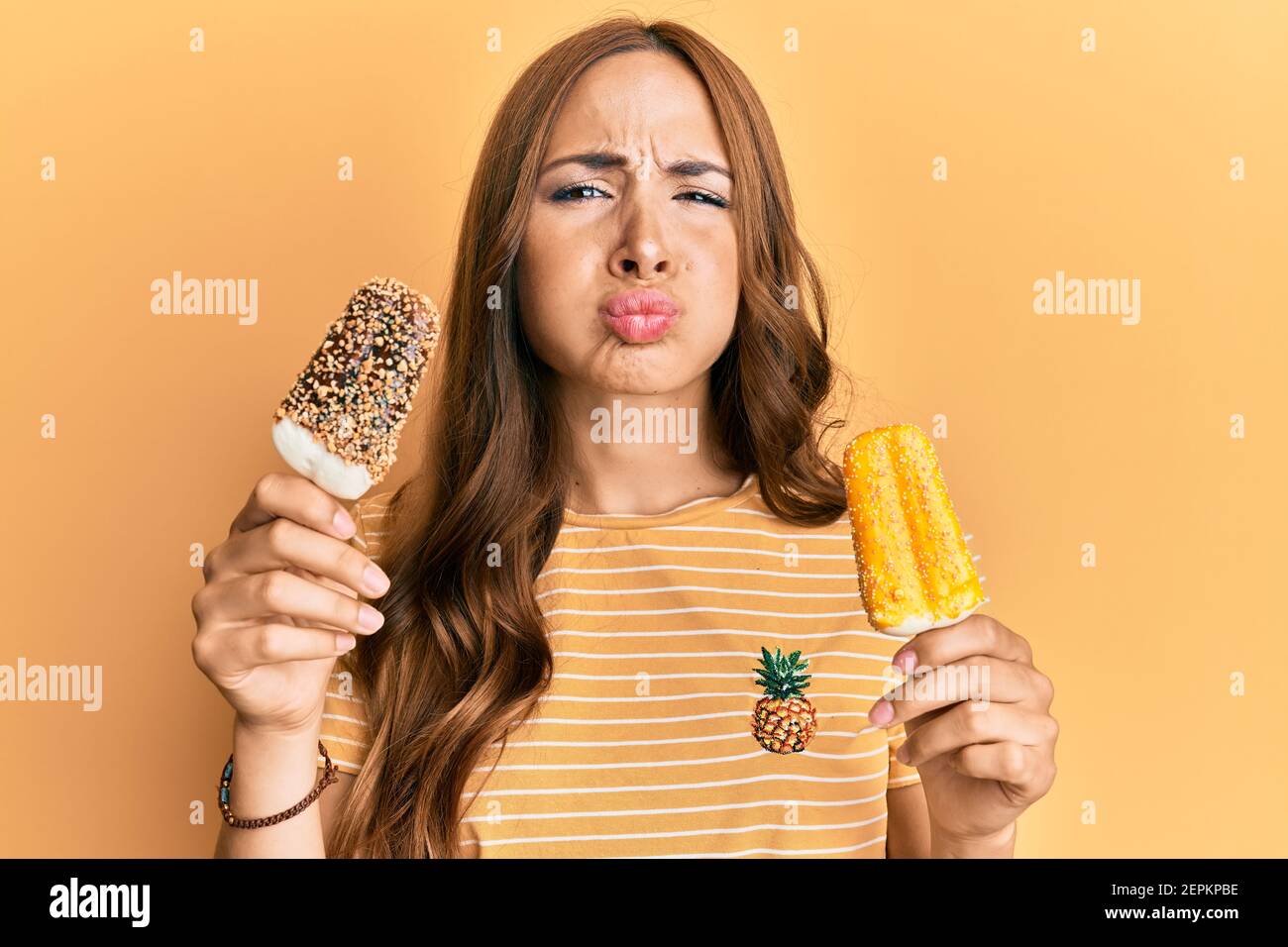 Young brunette woman wearing summer style holding ice cream puffing ...