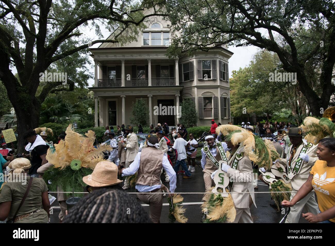 A vibrant second line parade marches past stately Uptown mansions in ...