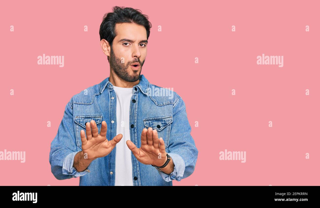 Young hispanic man wearing casual clothes moving away hands palms ...