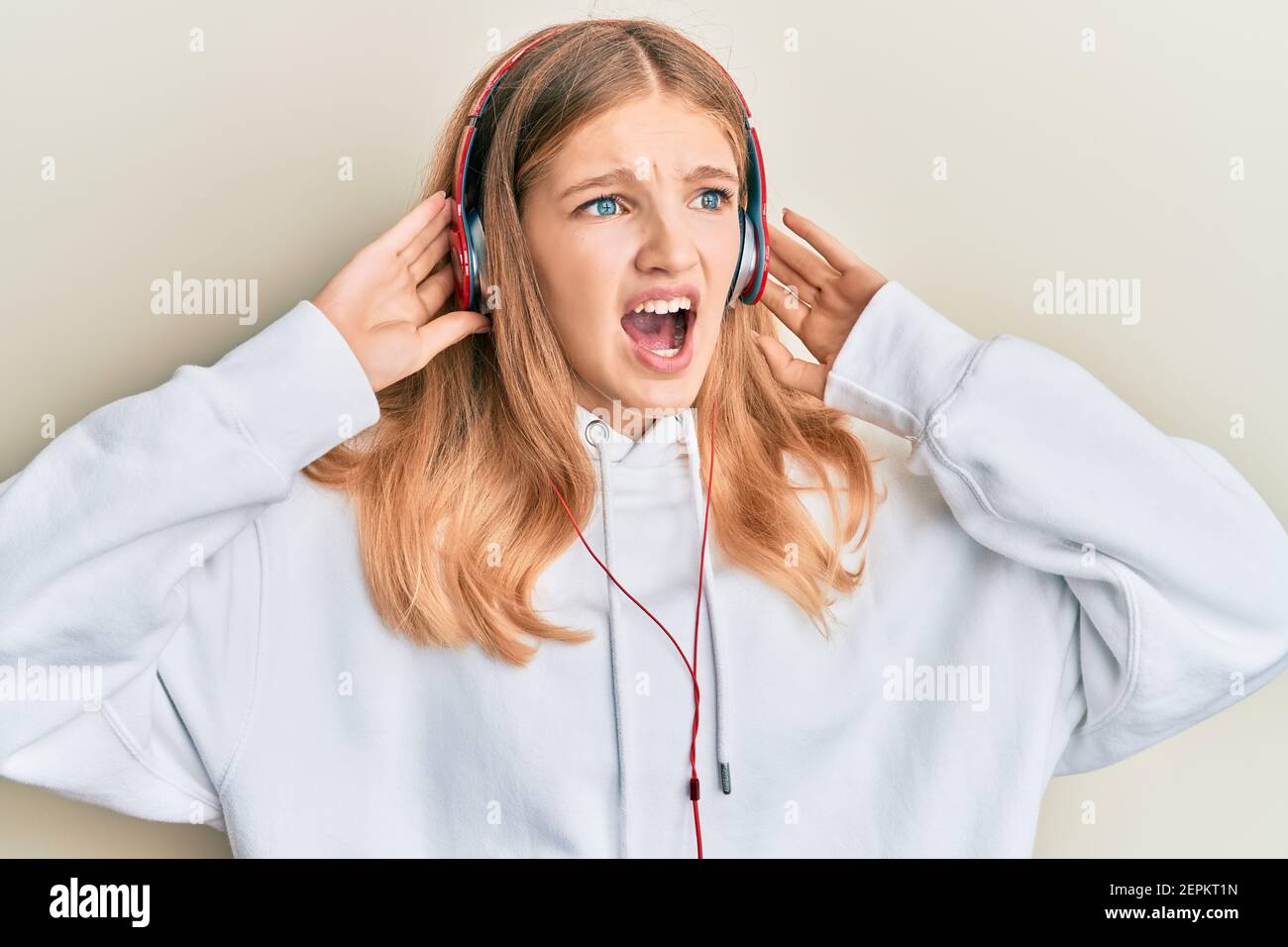 Beautiful young caucasian girl listening to music using headphones ...