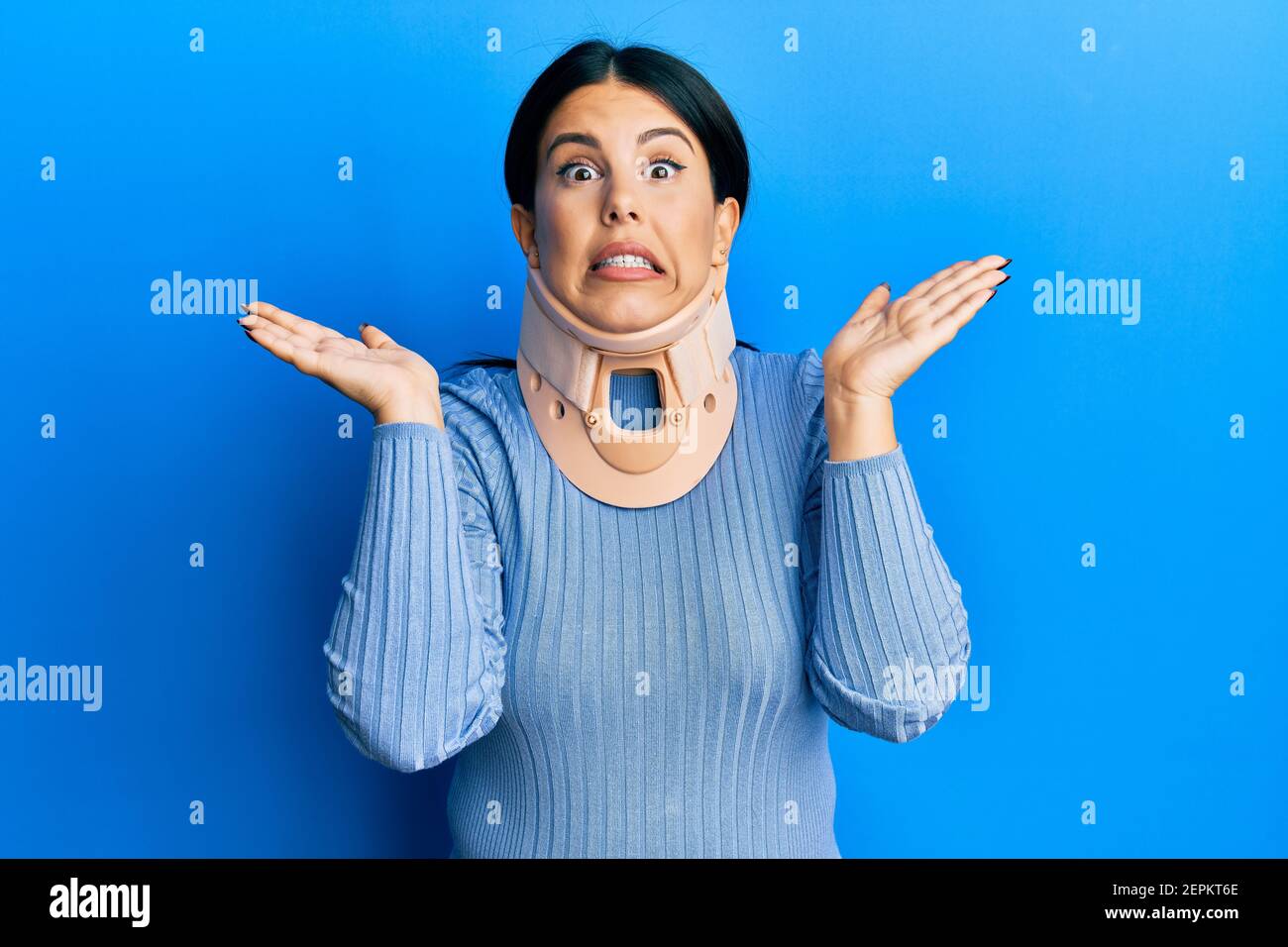 Beautiful brunette woman wearing cervical collar clueless and confused ...