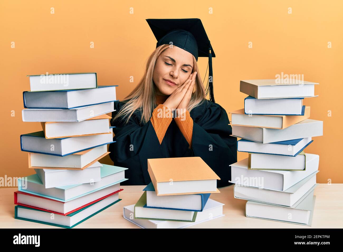 Young caucasian woman wearing graduation ceremony robe sitting on the ...