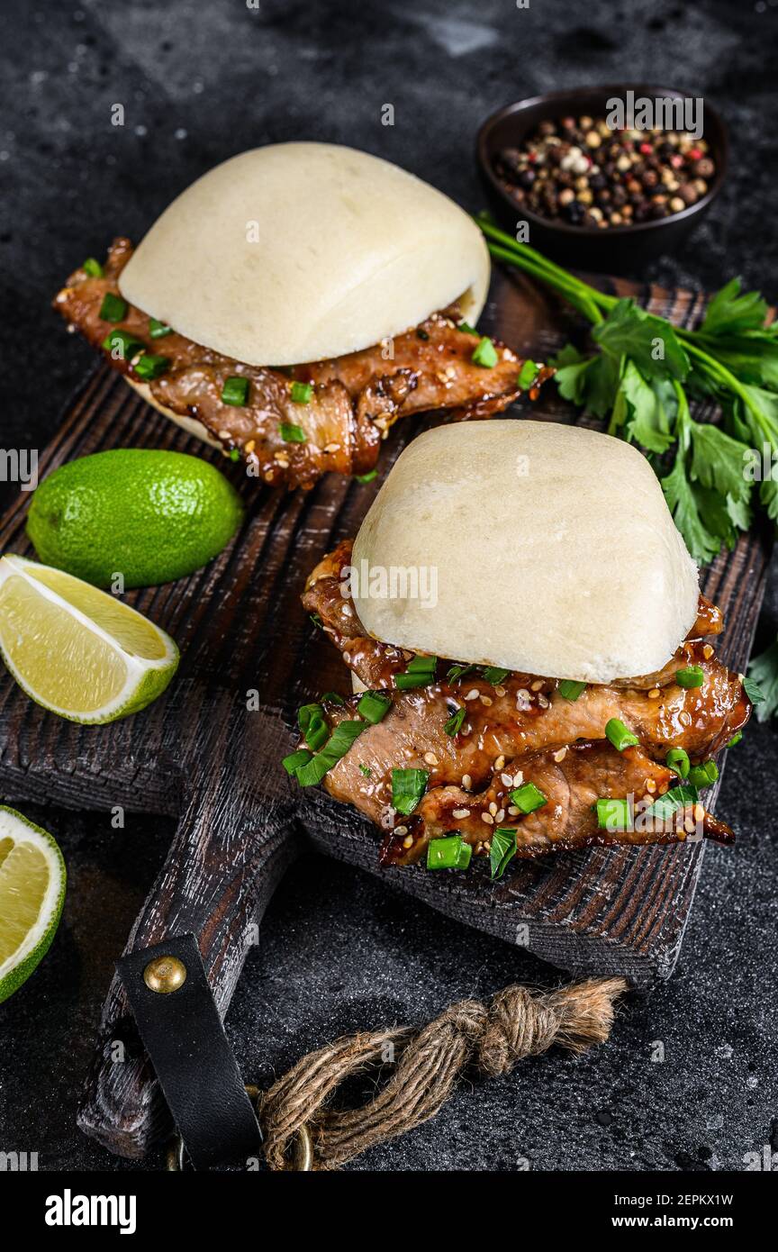 Bun bao steamed with pork belly and vegetables. Black background. Top ...