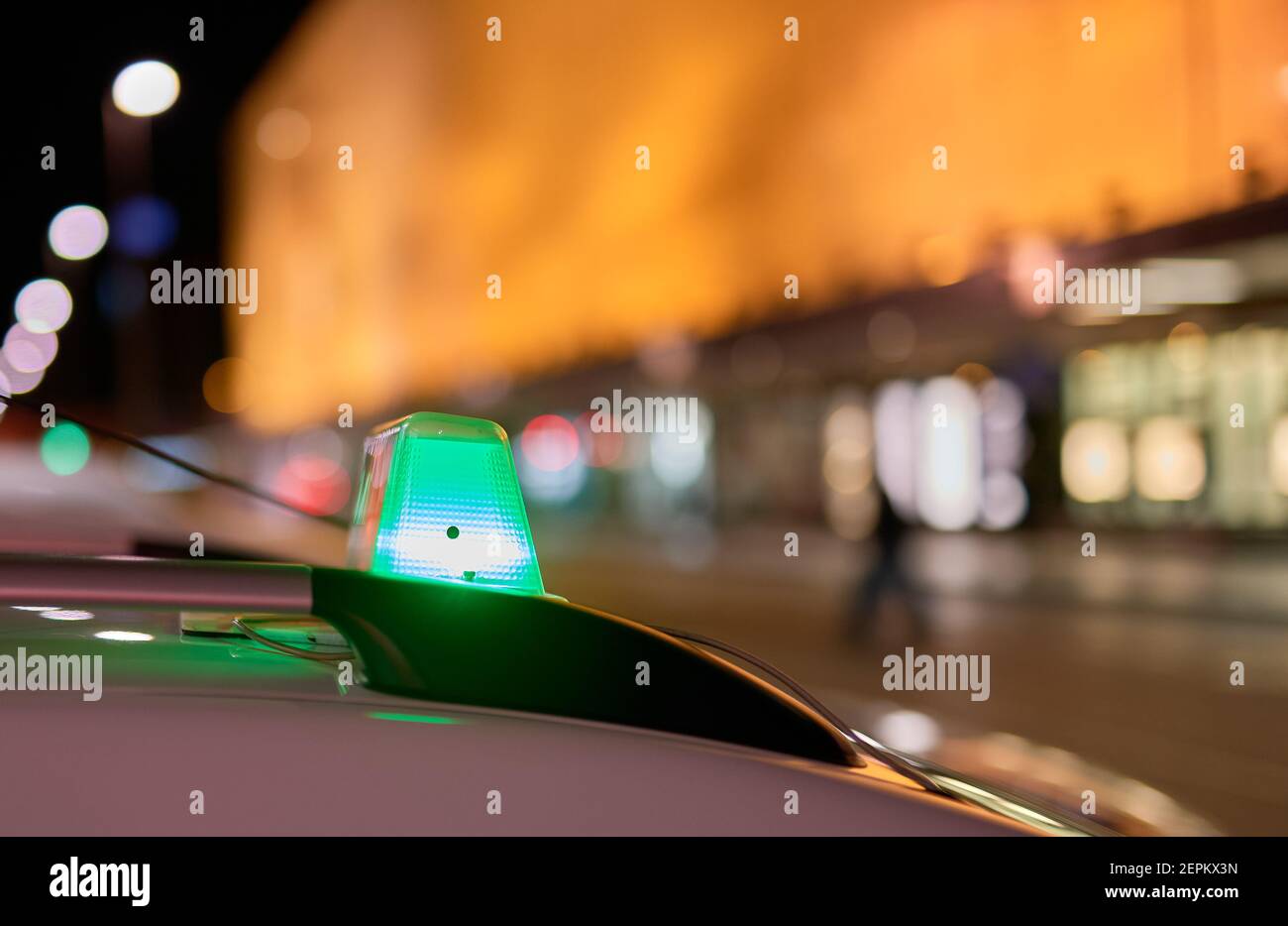 detail of the green light of a cab in a city indicating it is free ...