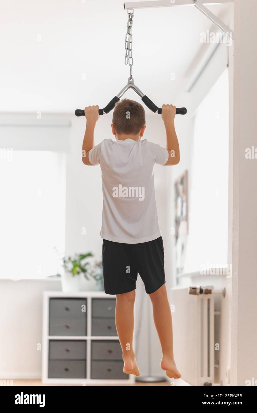 Younf boy doing pull-ups at home, stay fit. Active lifestyle Stock ...