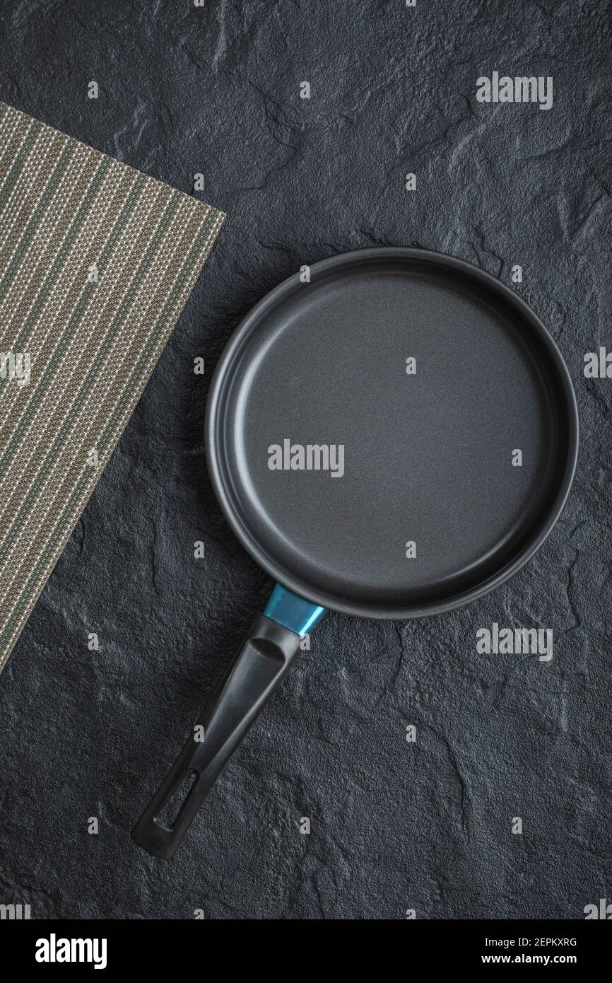 Empty frying pan for cooking placed on black background Stock Photo - Alamy