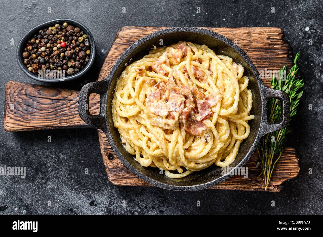 Pasta Carbonara with bacon and parmesan in a pan. Black background. top ...