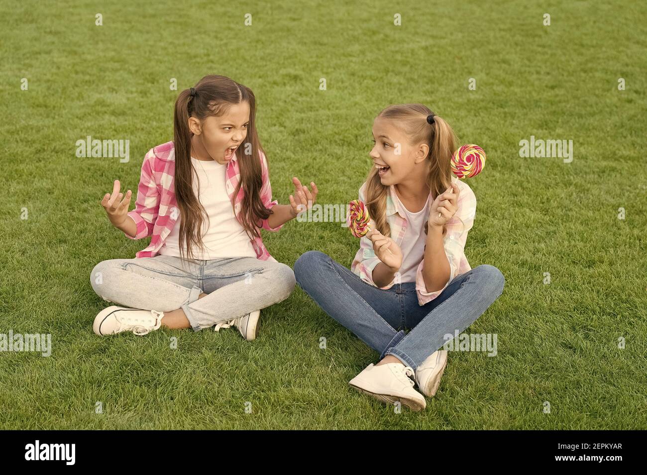 Sweets are bad for my teeth. Unhappy child show teeth to little girl ...
