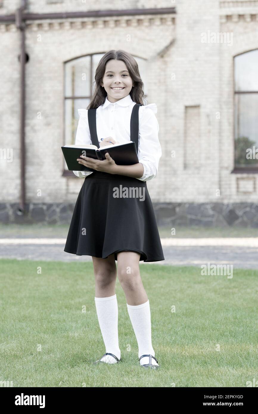 Lesson for discerning reader. Happy schoolgirl make notes for lesson ...