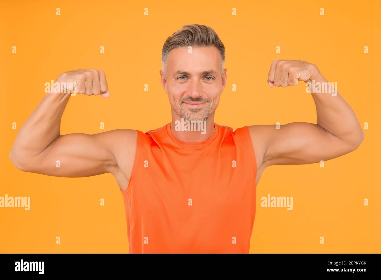 Train hard be strong. Strong man flex arms yellow background. Building ...